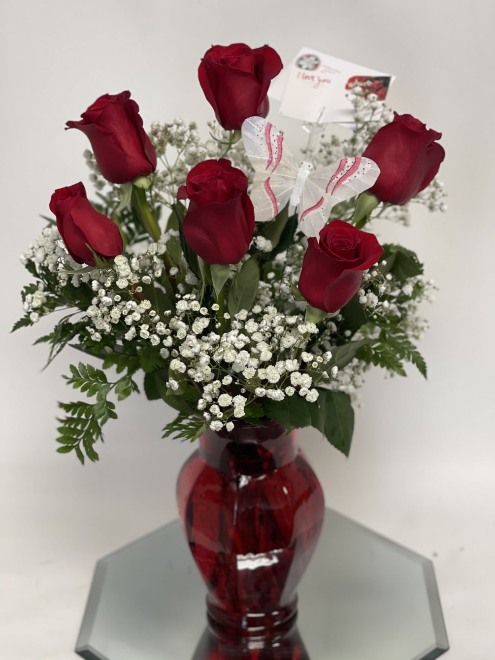 Red roses in red glass vase by Casa Blanca Flowers