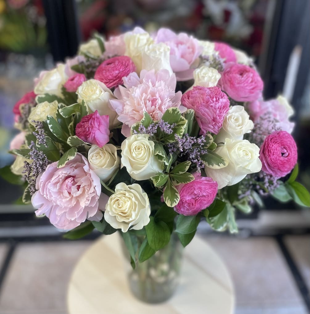 Peonies , ranunculus and roses arrangement in a vase. The photo shows a ...