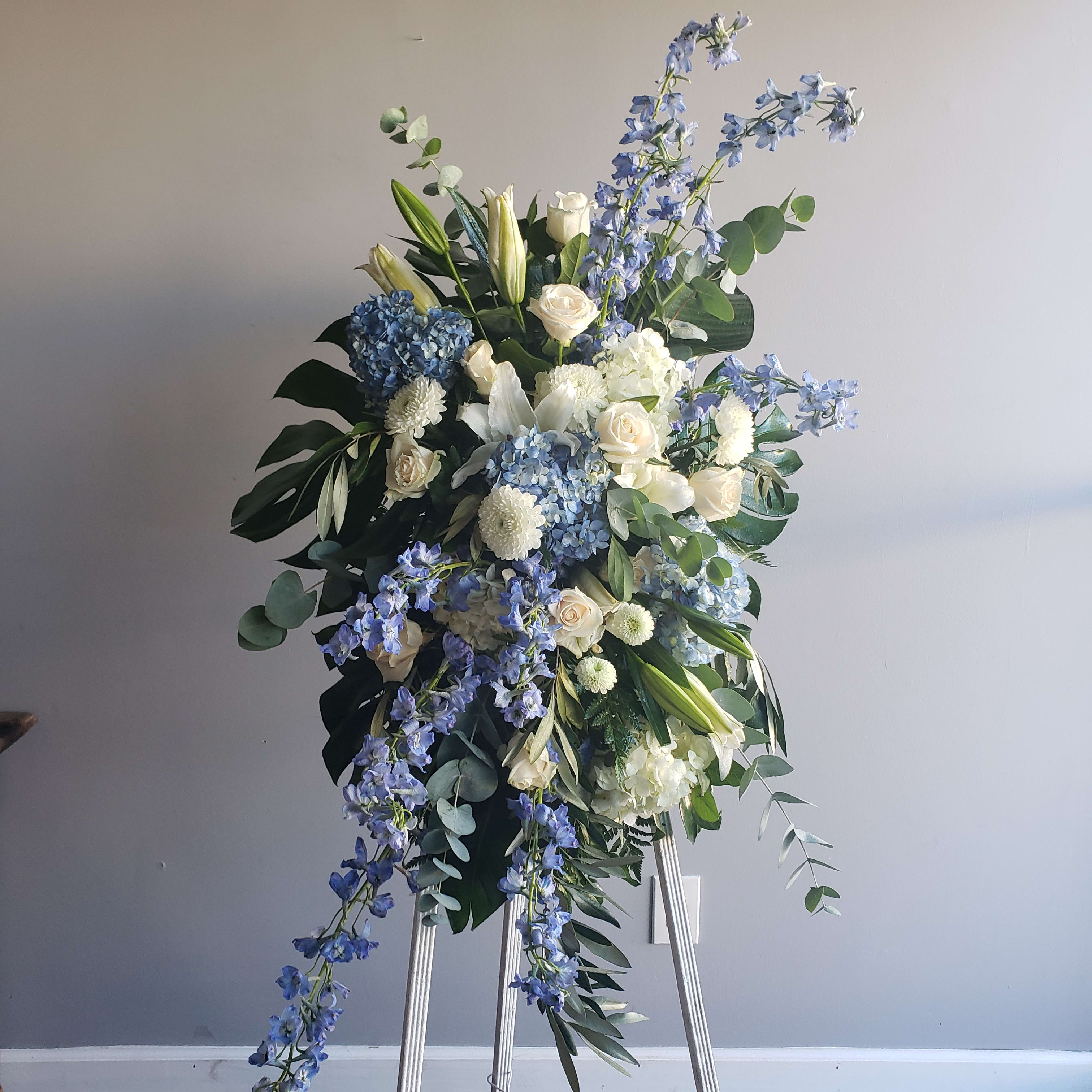 Blue and White Standing Funeral Spray by Isha Foss Design